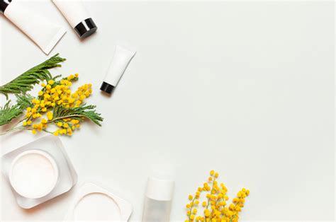 밝은 배경 상단에 노란색 미모사 꽃 흰색 화장품 병 용기 플랫 누워 화장품 Spa 브랜딩 모의 천연 유기농 미용 제품 컨셉