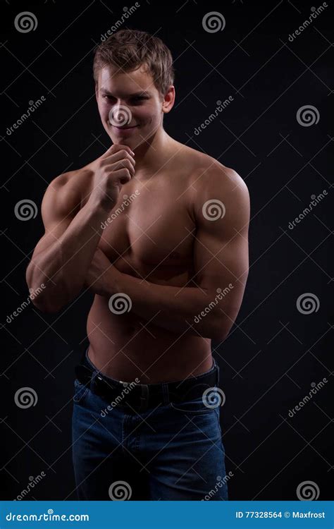 Muscle сексуальный нагой молодой человек представляя в джинсах Стоковое