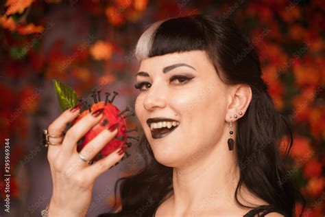 Beautiful Halloween Girl In Black Pin Up Clothes With Dead Red Apple In