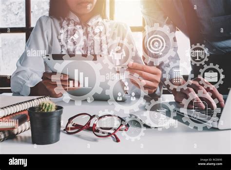 Two Colleagues Discussing Data With New Modern Computer Laptop And Tablet On Desk Table Close