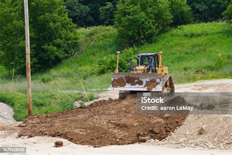 Caterpillar D9 불도저는 23번 고속도로 확장의 기초를 건설하기 위해 토지를 평평하게 하기 위해 흙 재료를 이리저리