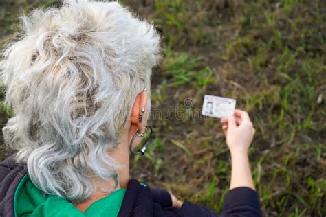 Non Binary Person Looking At Their New Name On The Identity Card Rear