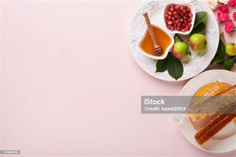 로쉬 하샤나 꿀 항아리 벌집 사과 및 석류가 단순한 분홍색 배경에 있습니다 유대인 새해 연말 인사말 카드 로쉬 하샤나 휴일 속성