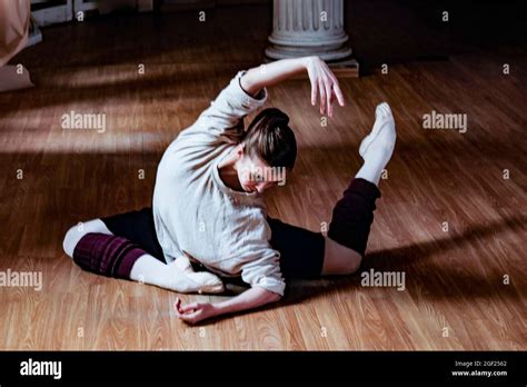 A Young Ballerina Stretches In Advance Of A Dance Rehearsal In A