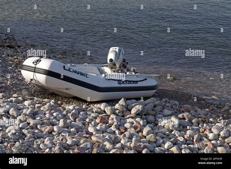 Small Inflatable Dingy With Outboard Motor Pulled Up On The Shore Tilos Greek Island Near