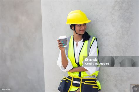 행복한 인도 여성 건설 엔지니어는 안전 안전모 헬멧을 쓰고 중공업 제조 공장에서 뜨거운 커피를 마신다 조립식 콘크리트 벽 20 24세에 대한 스톡 사진 및 기타 이미지