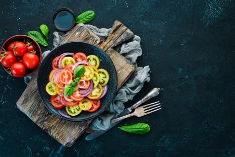 신선한 토마토와 검은 판에 양파 샐러드 에 오래 된 배경 최고의 볼 수 있습니다 텍스트에 대 한 여유 공간입니다 고급 요리에