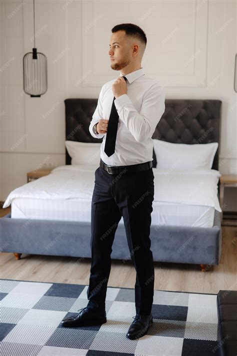 Premium Photo A Man In A White Shirt Is Standing In Front Of A Bed