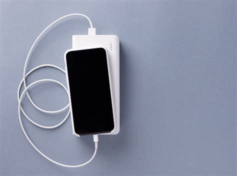 Premium Photo Smartphone Charged Via A Usb Cable From The Power Bank Charger