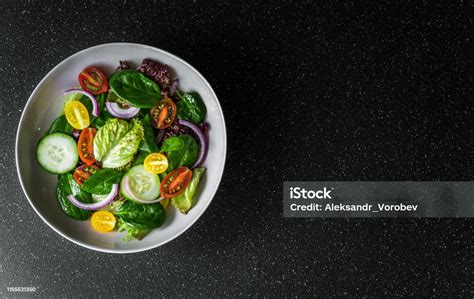 양상추 시금치 체리 토마토 붉은 양파가 있는 채소 야채 샐러드 그릇의 평면도 건강 한 음식 채식주의자 및 비 건 음식 피트 니스 스포츠 및 라이프 스타일의 개념 건강한 생활