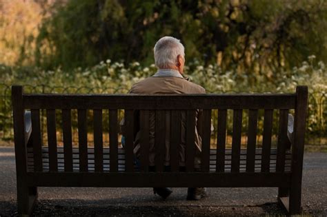 Полный выстрел старик сидит на скамейке Премиум Фото