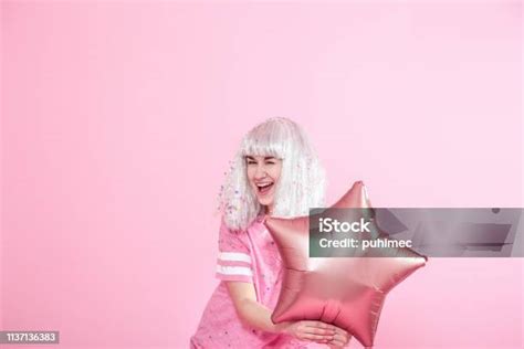 은색 머리를 가진 재미 있는 소녀는 분홍색 배경에 미소와 감정을 제공 합니다 풍선 및 색종이와 젊은 여자 또는 십 대 소녀