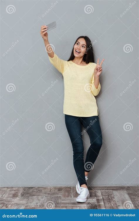 Smiling Woman Taking Selfie With Smartphone And Showing Peace Sign