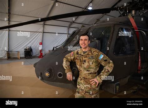 Capitaine Tyler Malder debout par lun des hélicoptères UH 60 Blackhawk