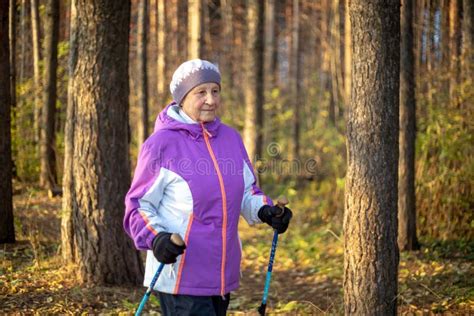 A Woman Over The Age Of 65 Is Engaged In Nordic Walking In The Fresh