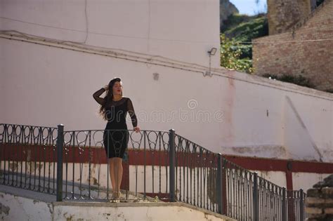 Young Beautiful Brunette Woman In An Elegant Black Dress Touching
