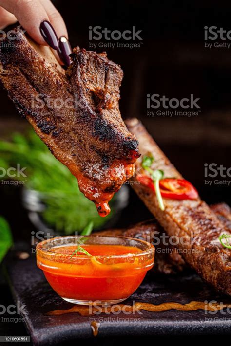 멕시코 요리 고추 화이트 레드 소스를 곁들인 돼지갈비 구이 검은 접시에 레스토랑에서 요리를 제공합니다 배경 이미지 복사 공간