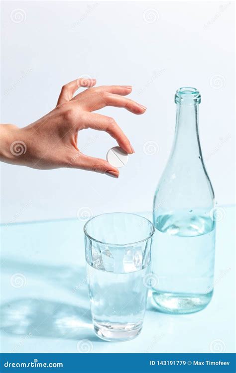 Female Hand Throws A Pill Into A Glass Of Water Minimalistic Concept