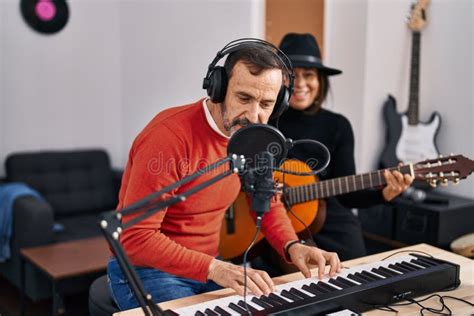 middle age man and woman musicians playing guitar and keyboard piano