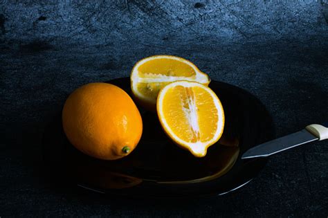 전체 레몬과 어두운 배경에 검은 접시에 두 개의 잘라 반쪽 0명에 대한 스톡 사진 및 기타 이미지 0명 감귤류 과일