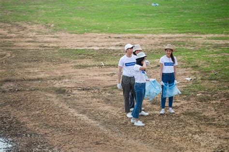 Group Of Volunteers Cheerful Success Arms Raised Holding Rubbish Bags