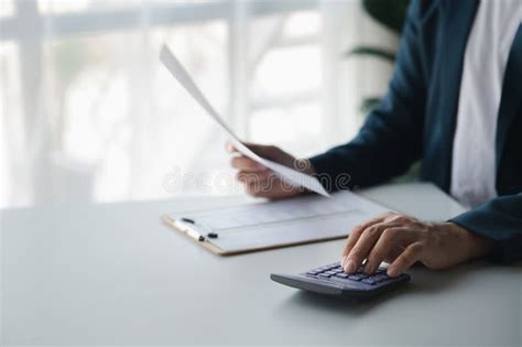 Businessman Using A Calculator To Calculate Numbers On A Company S