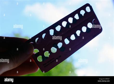 A Hand Holding Up An Empty Packet Of Contraceptive Pills Against A