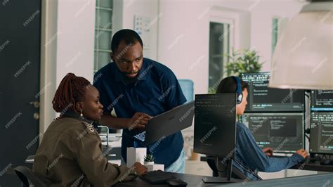 Premium Photo Team Of Software Developers Talking About Source Code Running On Laptop To Work