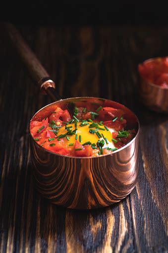 Shakshouka 전통 이스라엘 아침 식사 토마토 고추 허브 소스에 데친 계란 나무 테이블에 구리 빈티지 요리에 제공 클로즈업