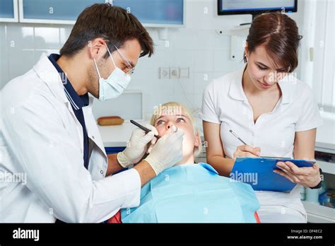 Dental Assistant During Apprenticeship Taking Notes While Dentist