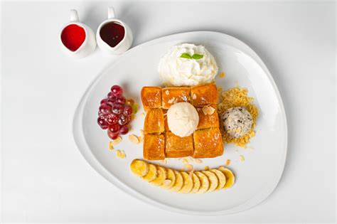 디저트 토스트를 얹은 바닐라 아이스크림 휘 핑 크림 봉사 포도 바나나 콩 꿀 흰색 바탕에 딸기 소스 0명에 대한 스톡 사진 및 기타 이미지 Istock