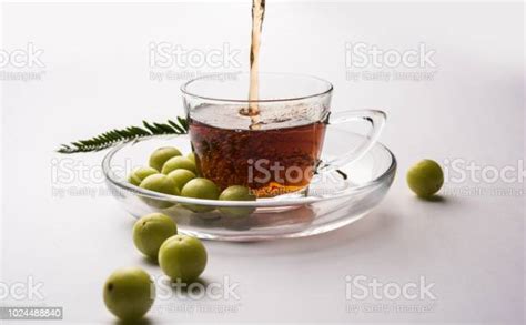 흰색 또는 검은색 배경에 Amla 차 또는 Avla 차이 접시와 투명 한 유리 컵에 붓는 인도에서 인기 있는 Ayurvedic