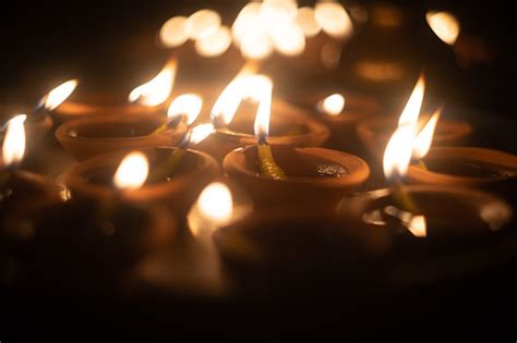 사이드 샷은 디왈리의 힌두교 축제 기간 동안 부와 번영을 가져 오는 여신 Lakshmi의 불꽃을 의미하는 배경에 보케가있는 많은