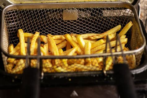 Cooking Potatoes In A Deep Fryer French Fries Are Removed From The Oil