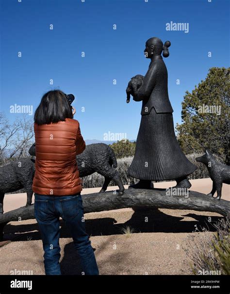 A Tourist Takes A Photograph Of A Bronze Sculpture By Renowned