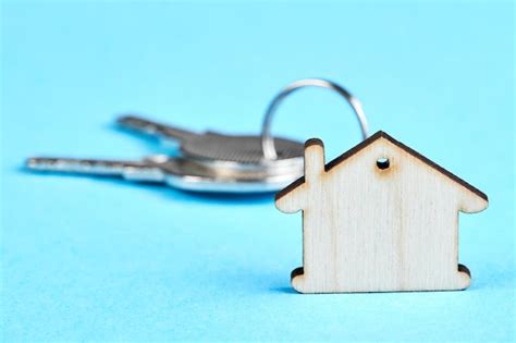 Premium Photo Trinket In The Form Of A Wooden House With The Keys To The Apartment