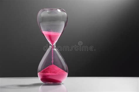 Hourglass With Pink Flowing Sand On Color Background Space For Text