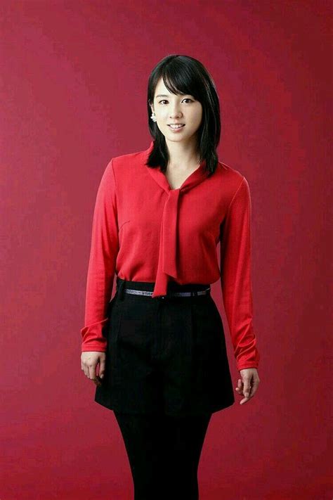 A Woman In A Red Shirt And Black Skirt Posing For The Camera With Her
