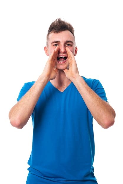 Молодой человек кричит через руки Бесплатно Фото