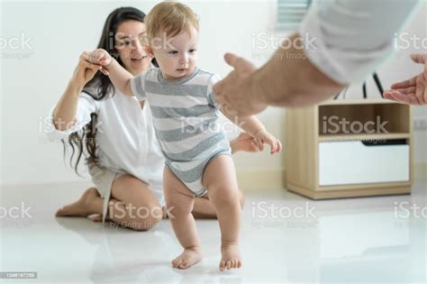 백인 젊은 귀여운 아기 아이 집에서 부모와 함께 걷는 법을 배웁니다 행복한 가족 어머니는 집에서 거실에서 기술을 개발하기 위해