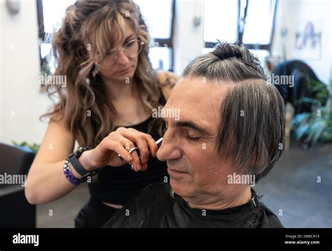 The Hairdresser Cuts The Hair Of An Elderly Client In His Own Salon