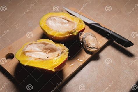 Yellow Mango And Big Pit On A Cutting Board At The Kitchen Table Fresh