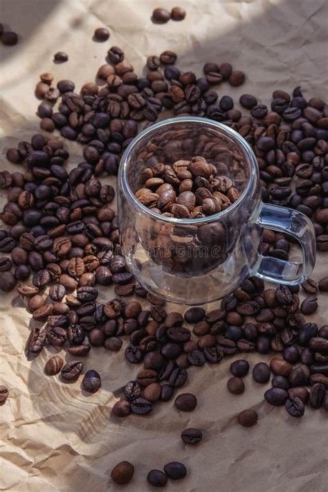 Coffee Beans In A Glass Cup On Brown Paper Background Stock Image
