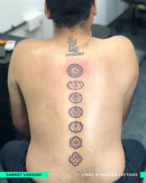 The Back Of A Man With Seven Chakras Tattooed On His Upper And Lower Back