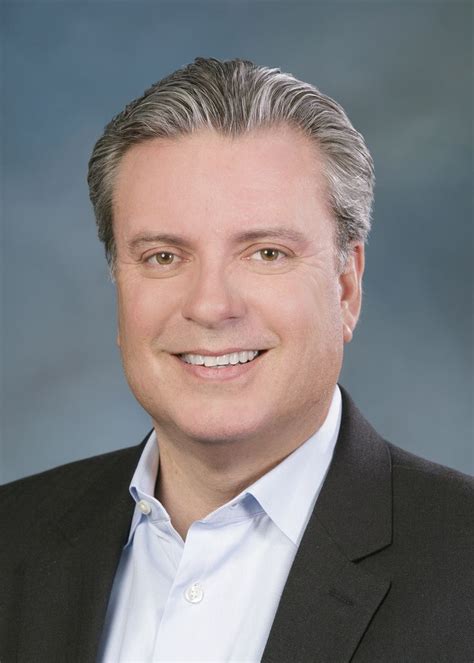 A Man In A Suit And White Shirt Smiling