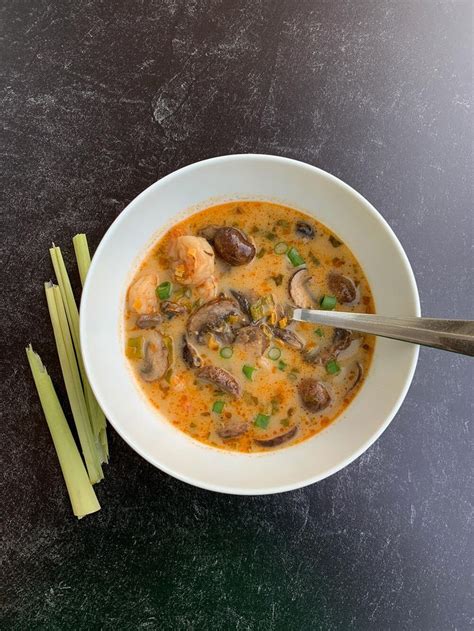 A Bowl Of Soup With Mushrooms And Celery Sticks On A Table Next To It