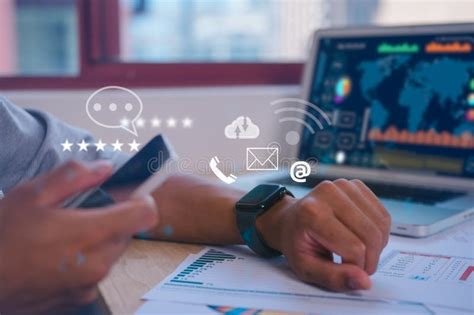 A Man Using A Generic Smartwatch With A Mobile Phone And Computer Laptop On Line For Searching