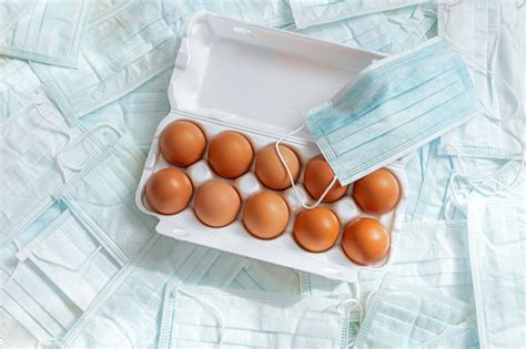 호흡기 보호 의료 마스크의 배경에 흰색 상자에 10 갈색 계란 글로벌 전염병 동안 부활절 휴일을 취소의 개념 플랫 레이 상단