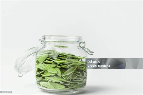 녹색 올리브 화이트 테이블 벽 배경에 오픈 뚜껑이 있는 유리 크리스탈 저장 항아리에 파스타를 떠난다 이탈리아 요리 명물입니다