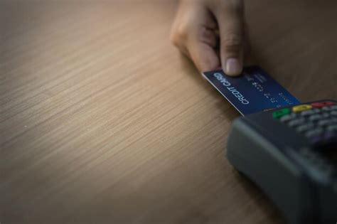 Premium Photo Cropped Hand Scanning Credit Card On Table